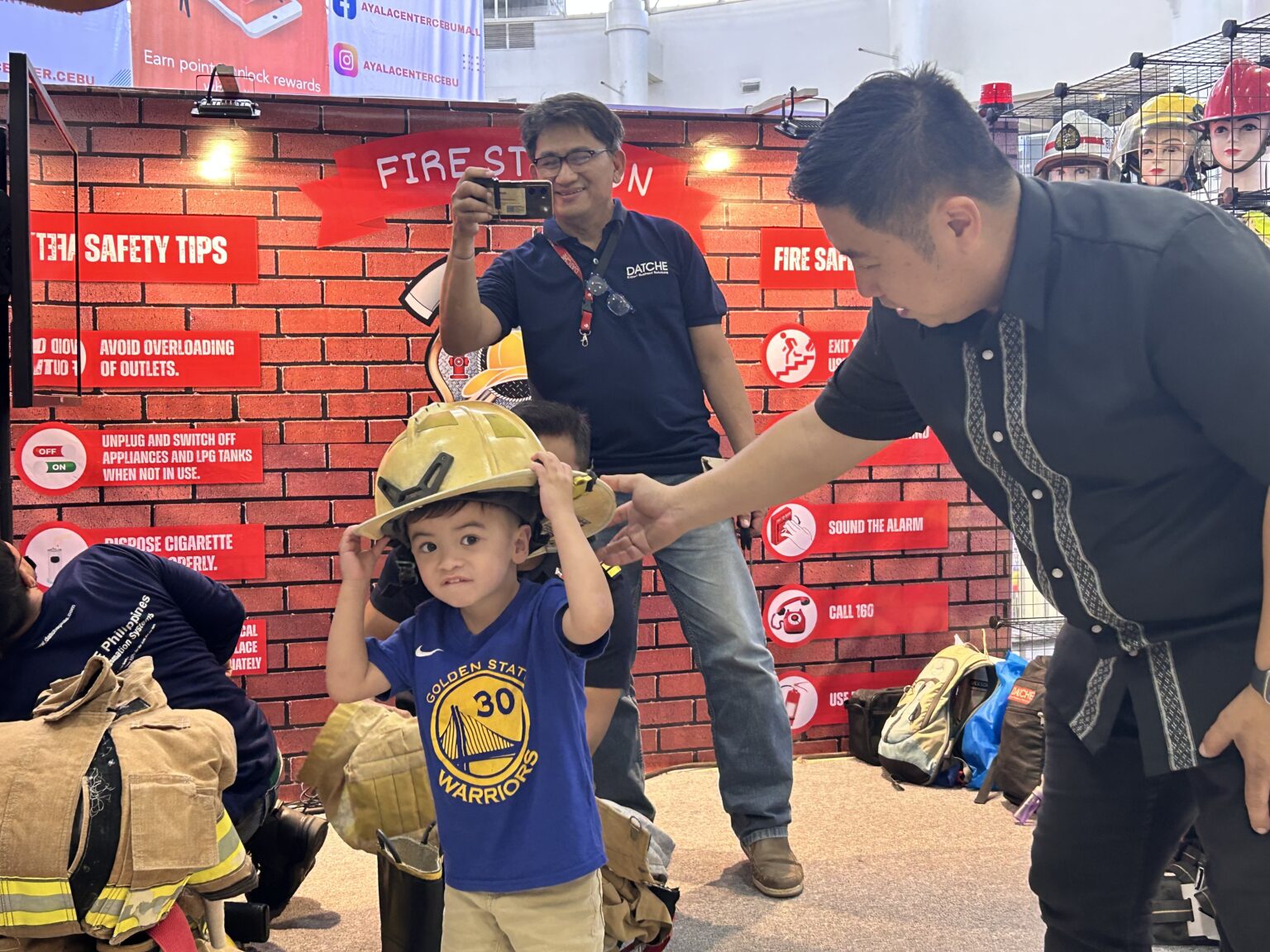 Fireman shows collection of firefighting equipment in mall exhibit