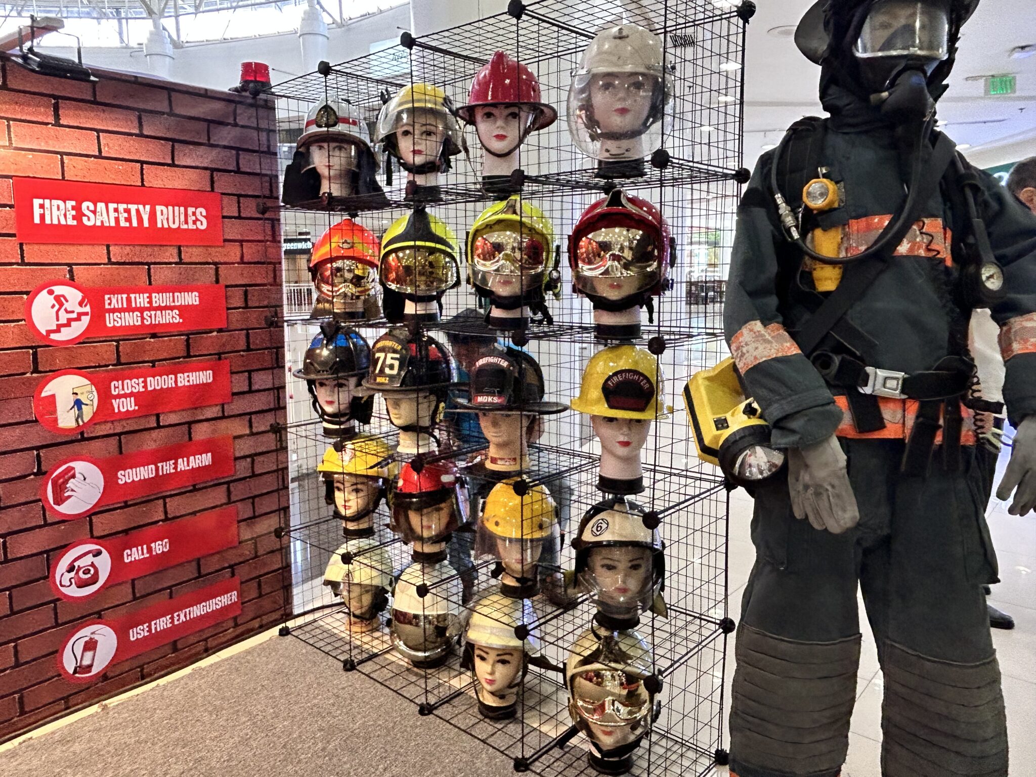 Fireman shows collection of firefighting equipment in mall exhibit